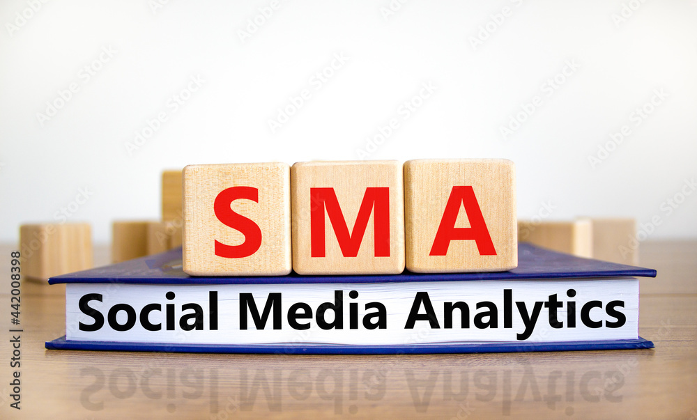 SMA social media analytics symbol. Wooden cubes on book with word 'SMA ...