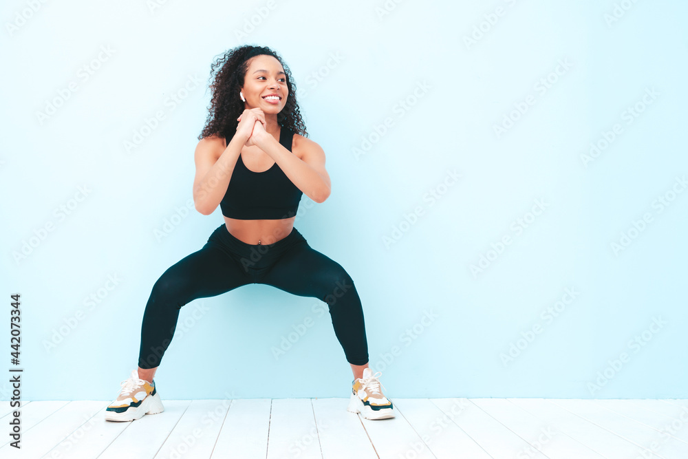 Fitness smiling black woman in sports clothing with afro curls ...