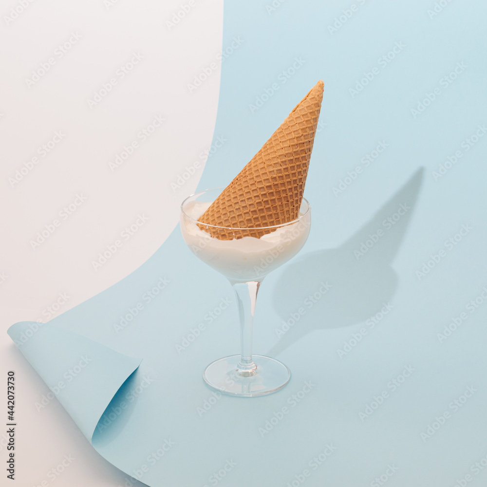 Melted ice cream in a glass with the cone inside turned upside down. A ...