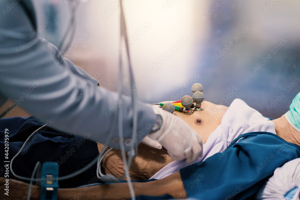 ECG or EKG of man with electrodes for electrocardiogram records on bed ...