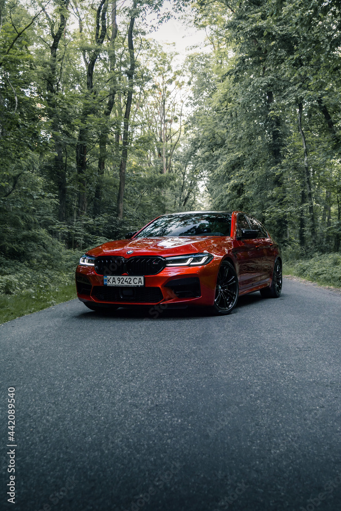 New BMW M5 F90 LCI Competition in a red color on the forest road. Kyiv ...