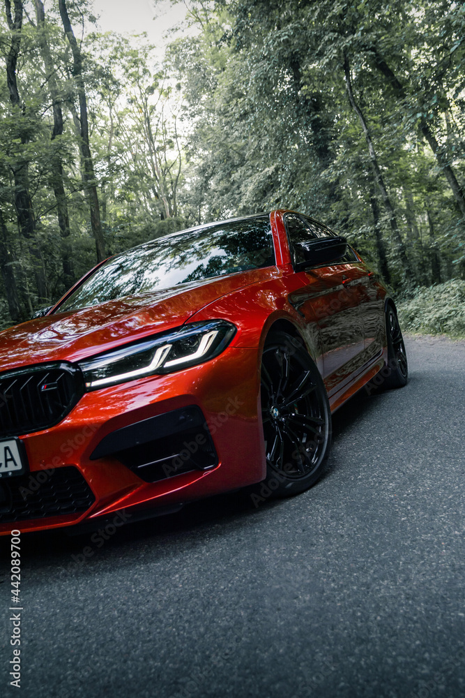 New BMW M5 F90 LCI Competition in a red color on the forest road. Kyiv ...