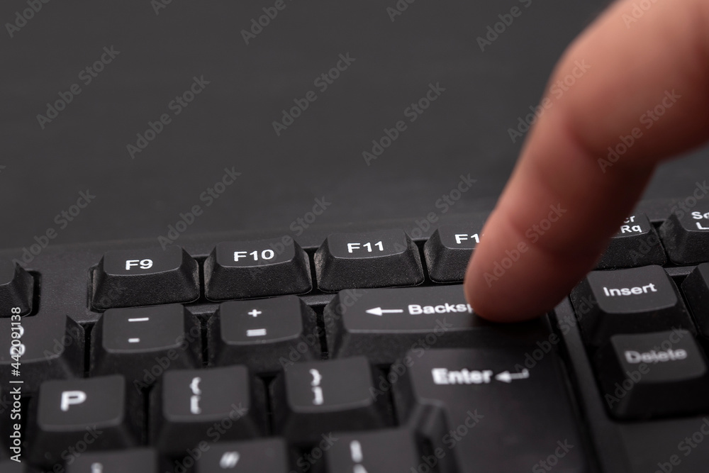 Backspace button on computer keyboard. Finger presses a key backspace ...