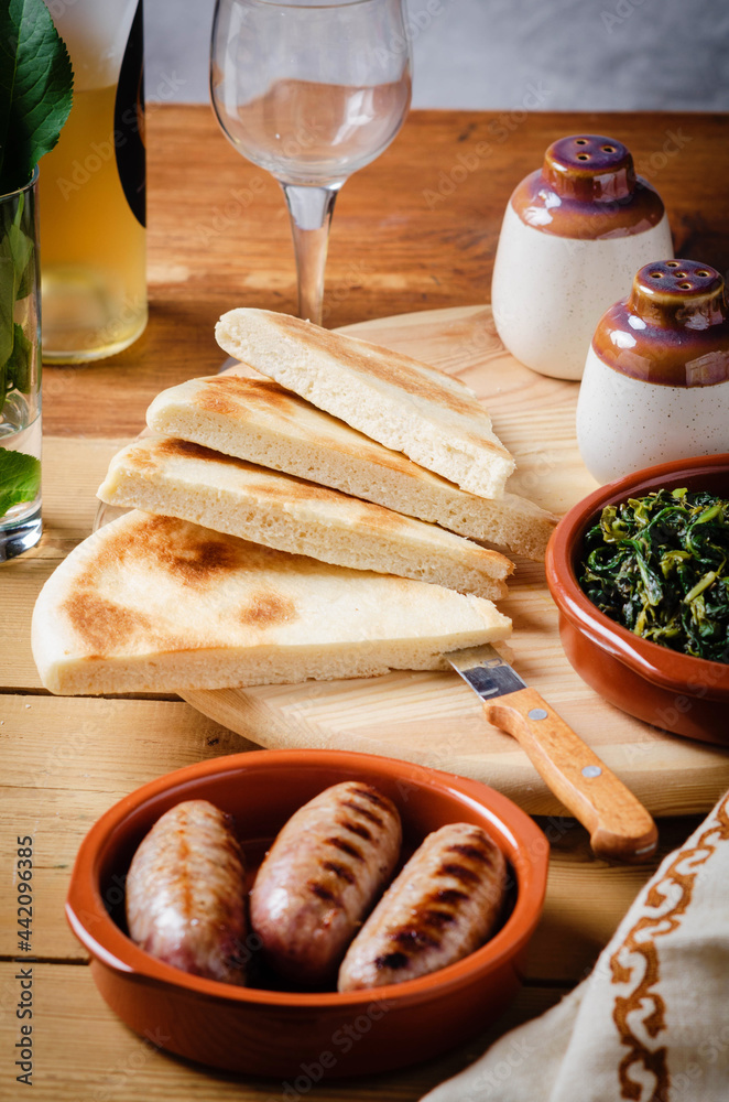 Foto de Torta al testo, flatbread with spinach and grilled sausage ...