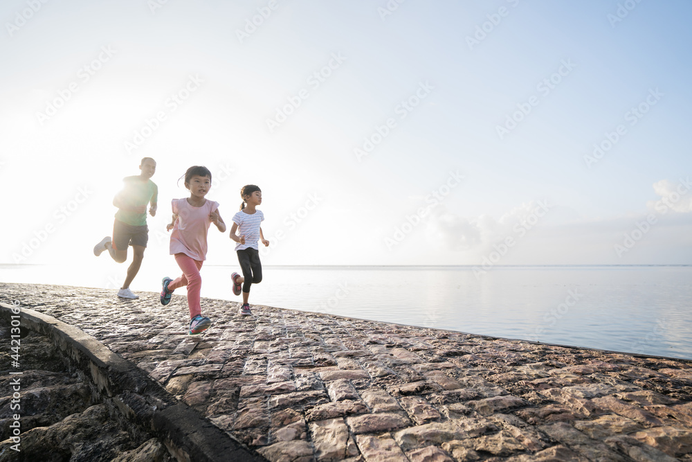 father and daughter do exercises running outdoor racing each other ...
