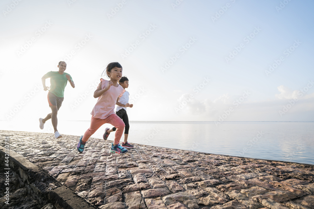 father and daughter do exercises running outdoor racing each other ...