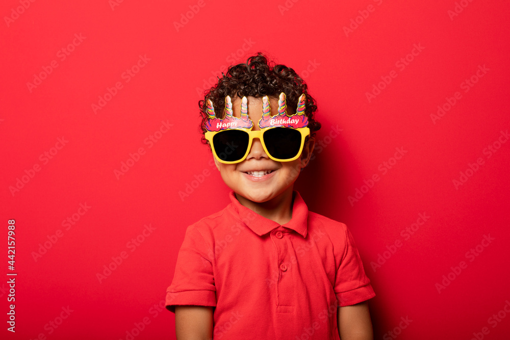 Cool boy in birthday glasses on red background Stock Photo | Adobe Stock