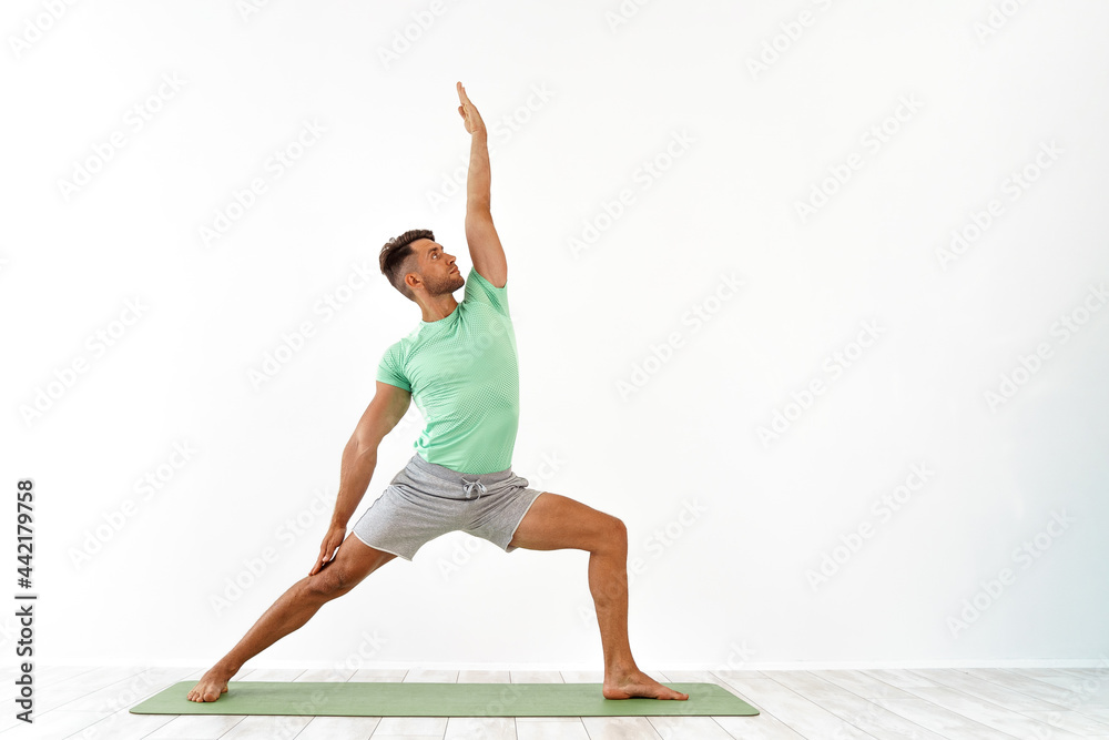 Attractive Young Man practicing advanced yoga on white background. A ...