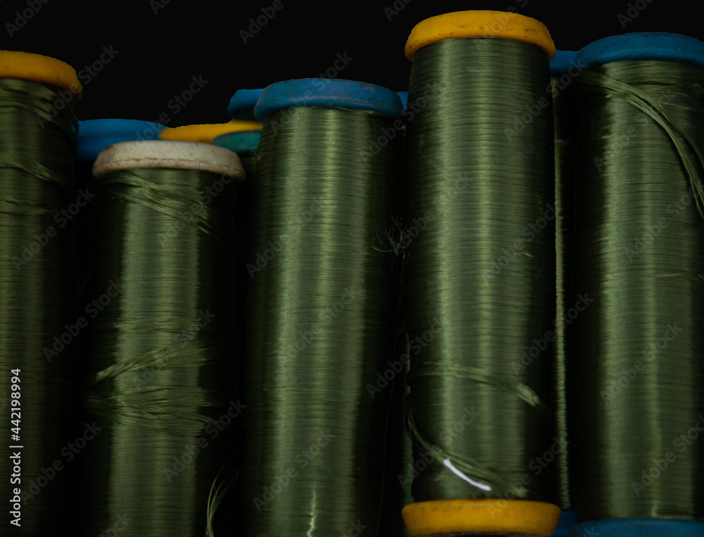 Spindles of olive green polyester filament material ready to make rope ...