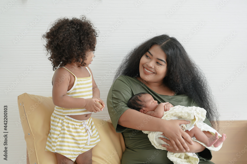 Foto de Happy African mixed race family, young mother take care of her son and daughter. Mom ...
