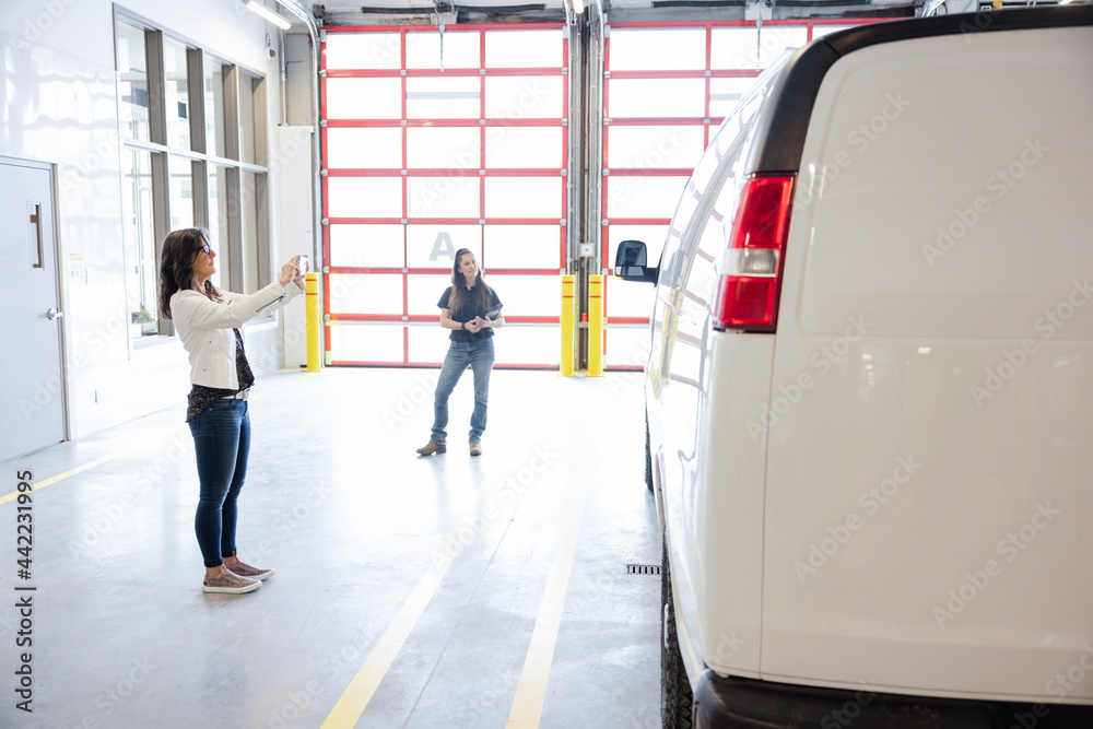 Woman photographing moving van in storage facility loading dock Stock ...