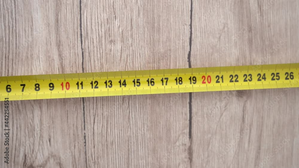 Measuring with yellow tape measure. Hands pull the measuring tape out ...