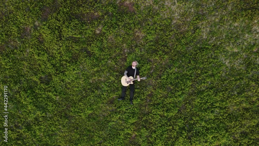 Top View a rock man lying on the ground and playing an acoustic guitar ...