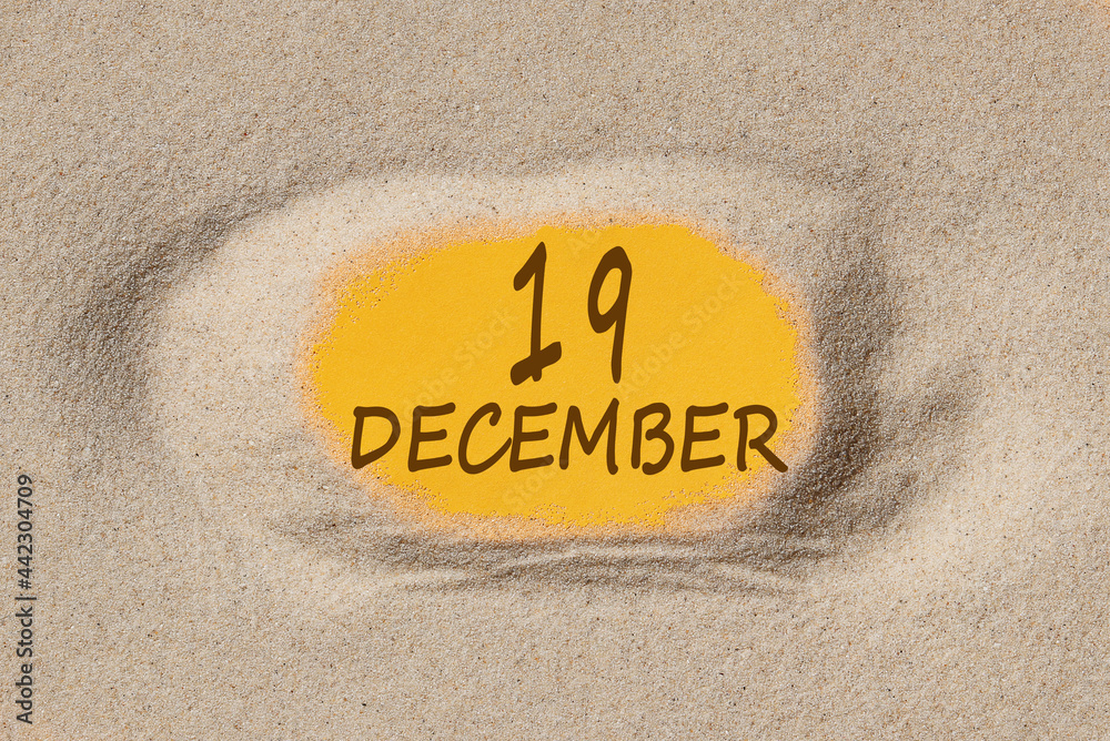 December 19. 19th day of the month, calendar date. Hole in sand. Yellow ...