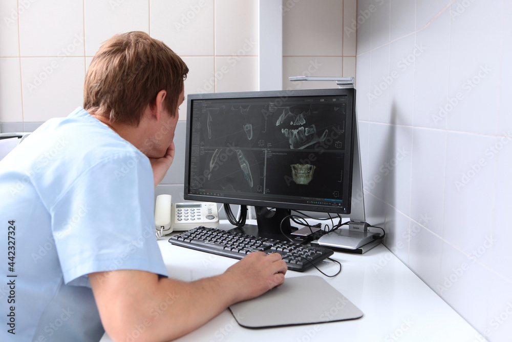 The dentist looks at the patient's CT scan. Preparation for the ...