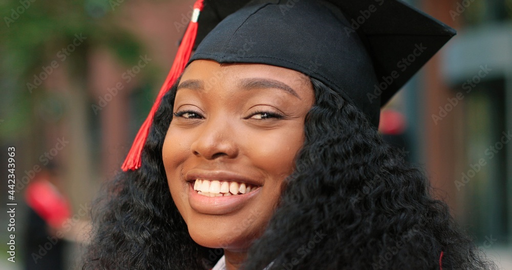 Young graduated curly girl holding her graduation degree convocation ...