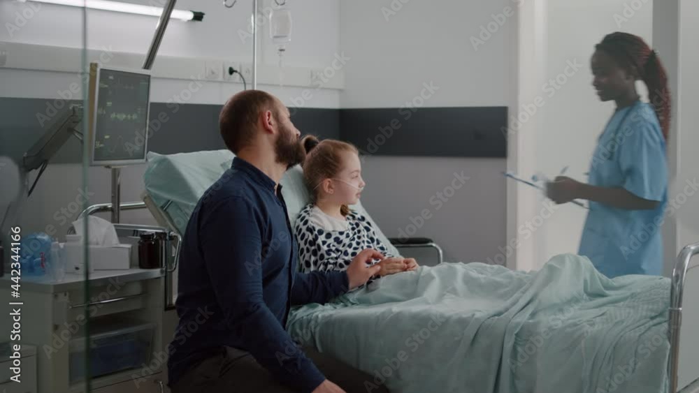 Father holding sick daughter hands during medical examination in ...