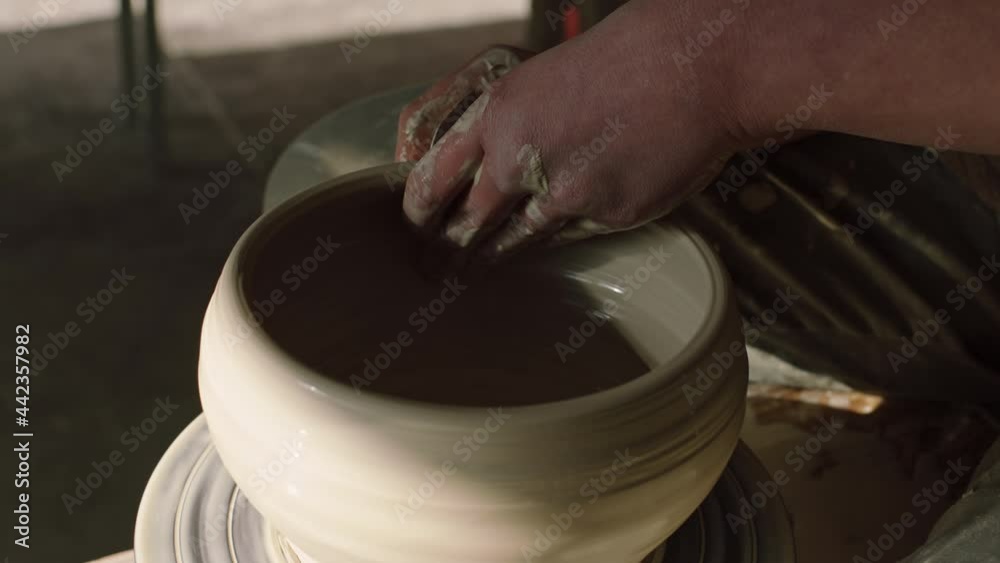 Beautiful clay pot is made by a potter, modelling raw clay on the ...