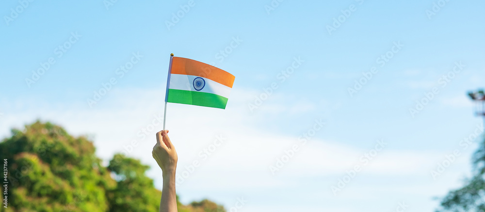 hand holding India flag on blue sky background. Holiday of India ...