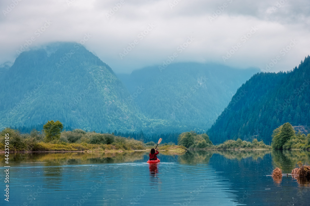 Adventure Caucasian Adult Woman Kayaking in Red Kayak surrounded by ...