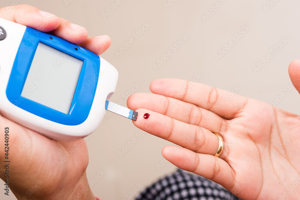 woman measuring glucose test level check with blood on finger by ...
