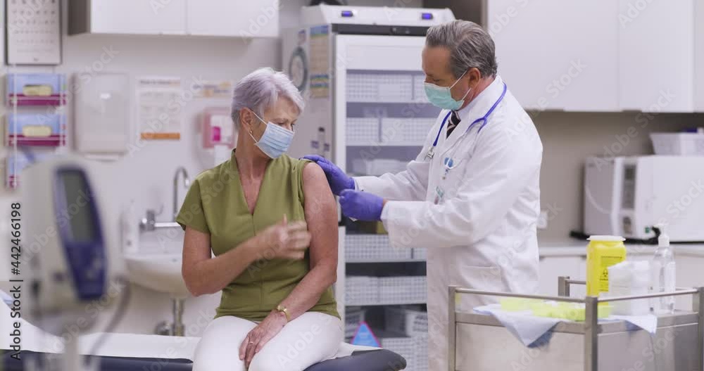 A Wide Shot Of An Australian Male Medical Doctor Administering A Covid ...