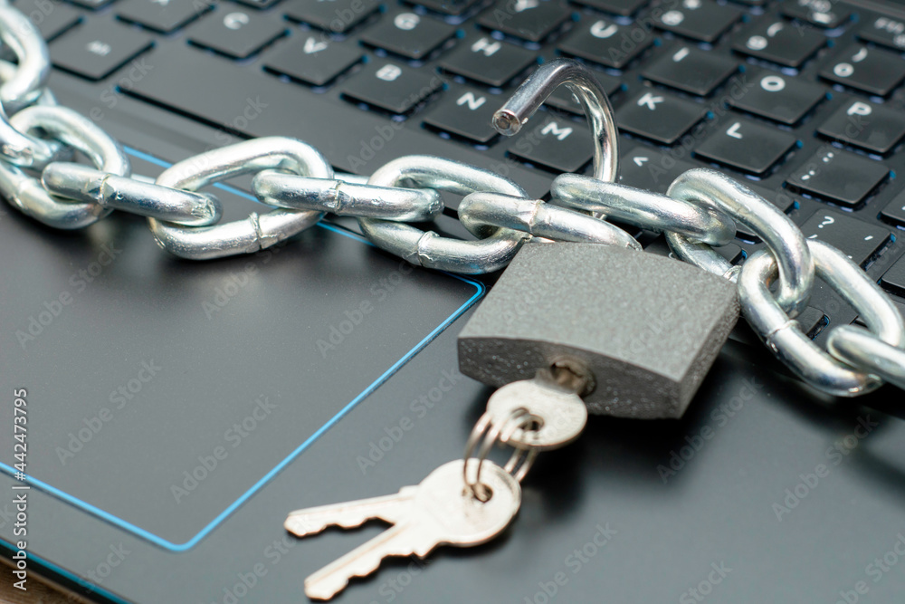 open hinged iron lock with keys and an iron chain on the laptop ...