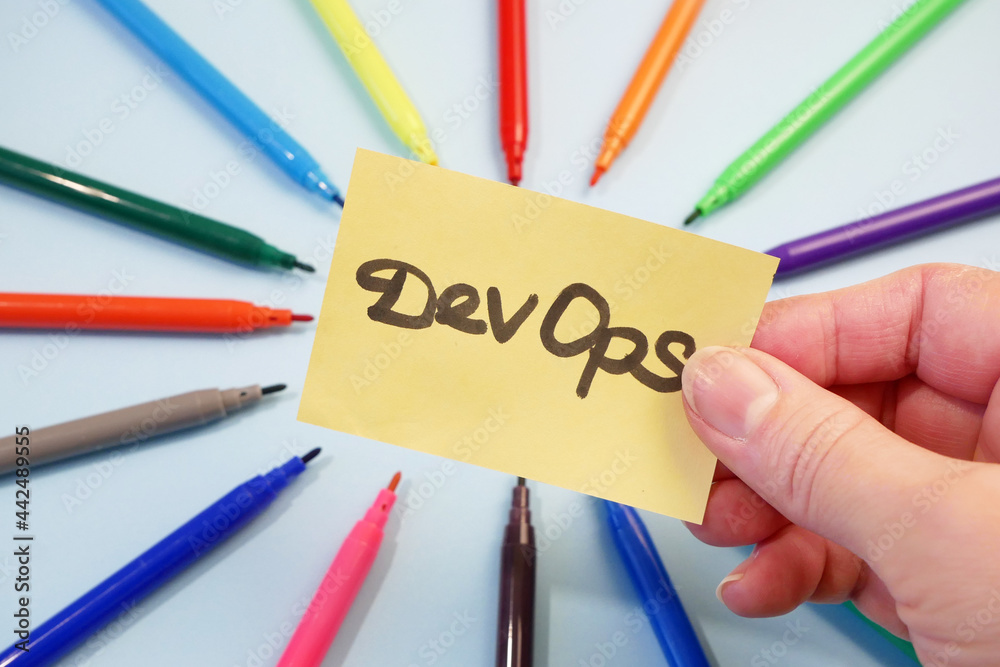 hand takes sticker with DevOps word, Concept for software engineering ...