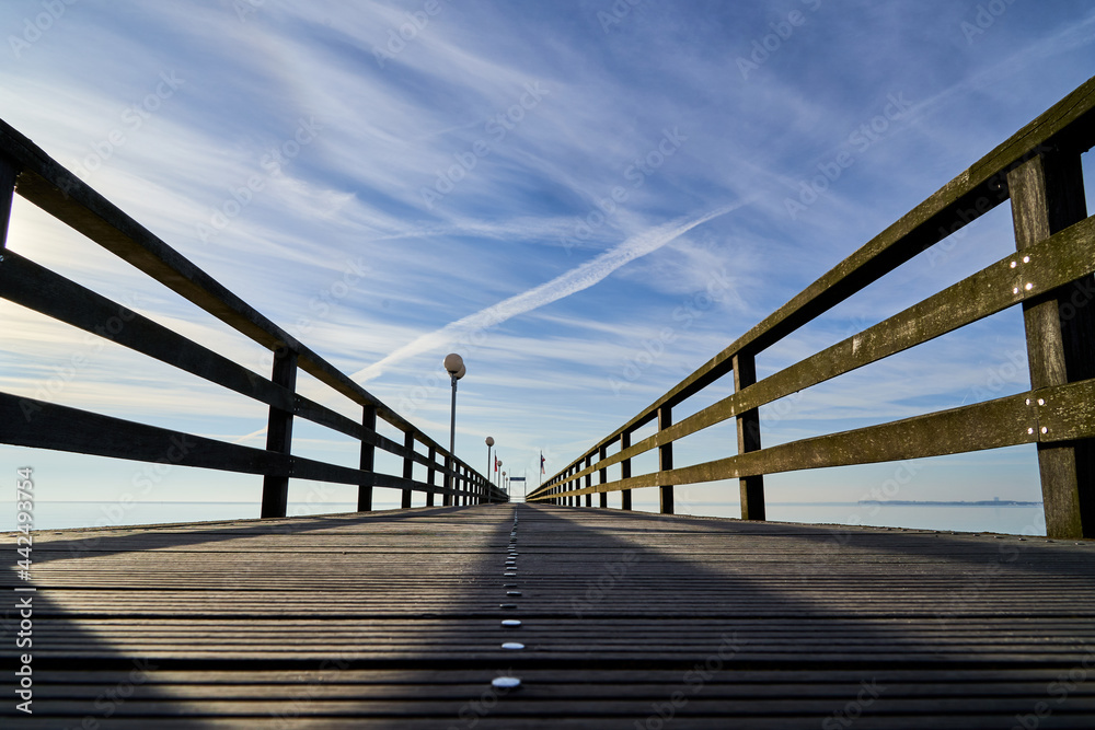 Ground view over an empty wooden pier with nails and a railing, central ...
