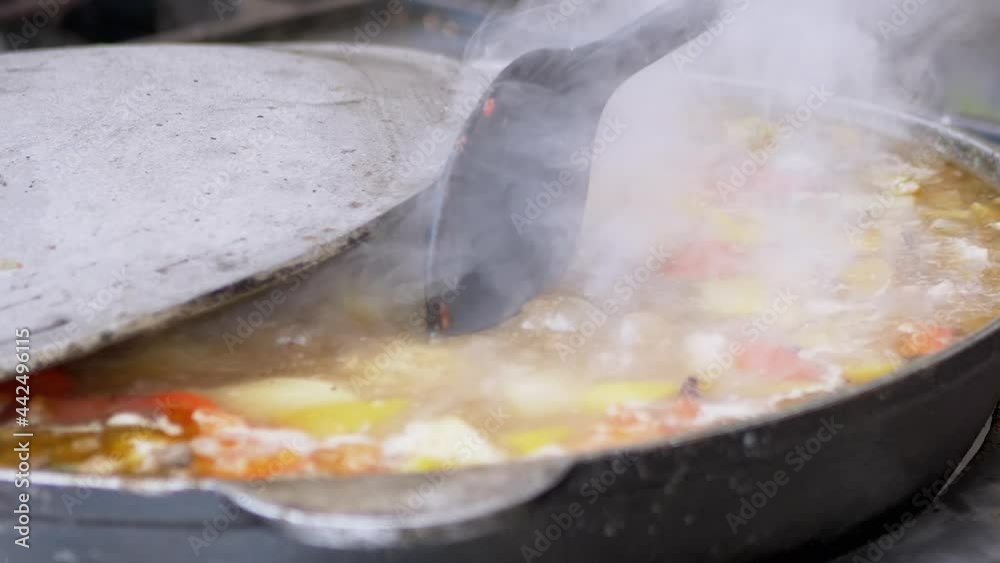 Street Chef Prepares a Vegetable Stew Outdoors in a Cast Iron Skillet ...