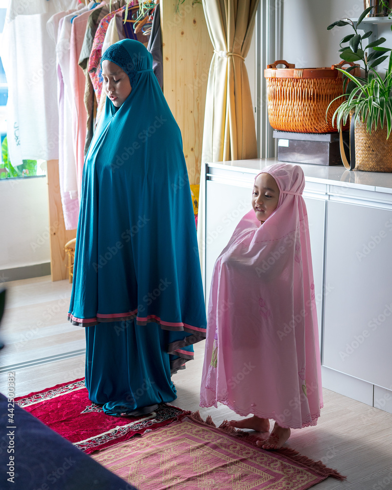 Muslim children praying at home. Learning to pray for the little girl ...