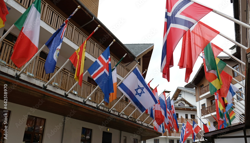 Many national flags of different states hang and blowing on building ...