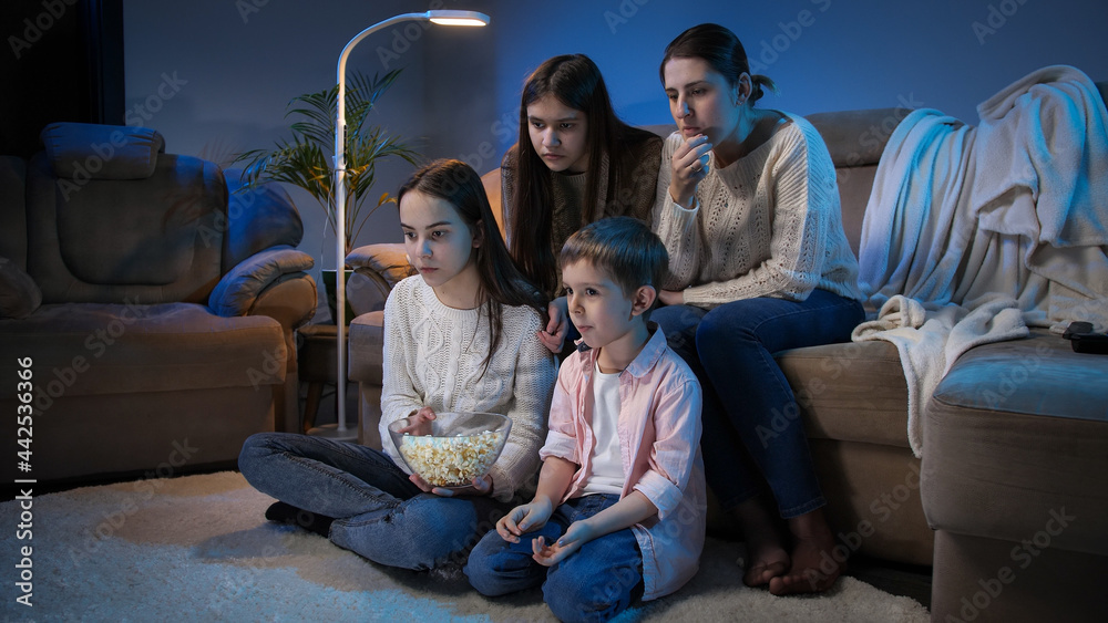 Family closing eyes and getting scared while watching horror movie or ...