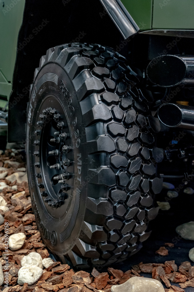Wheel of an armored car. Close-up of a large off-road armored car tire ...