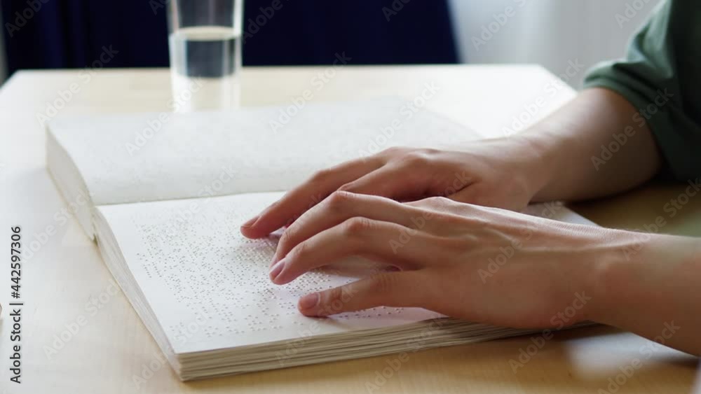 Blind person reading braille book, touching letters on sheet of paper ...