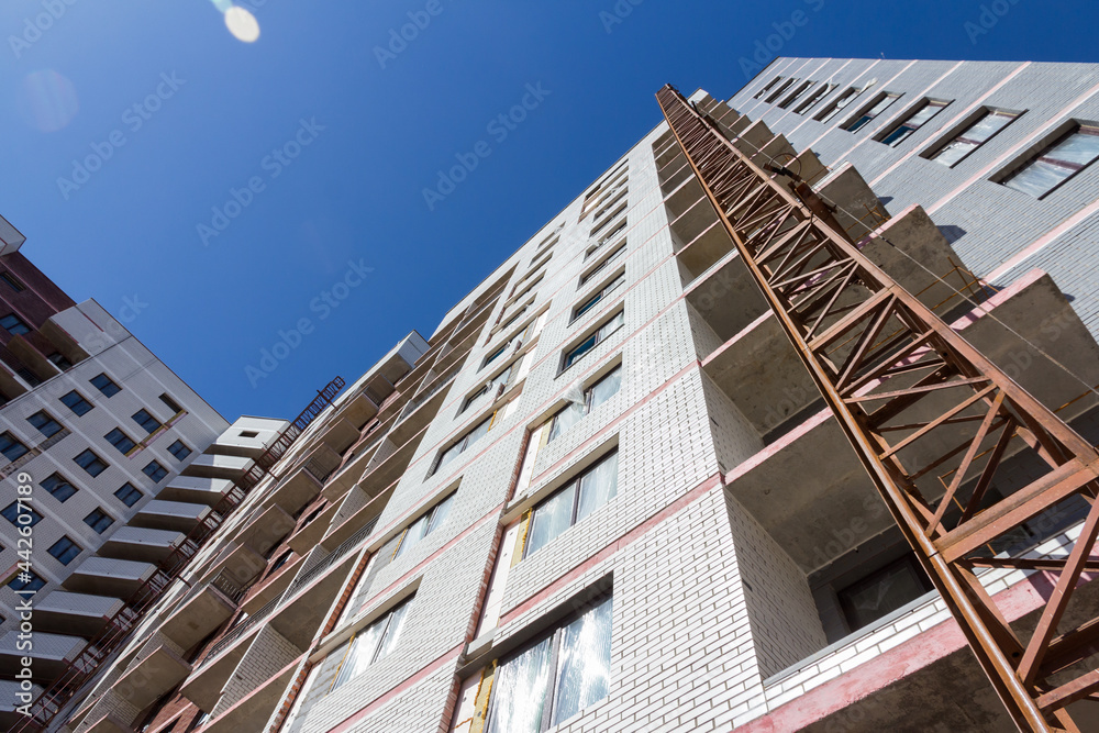 Lifting mechanisms at a construction site. Elevator mast against the ...