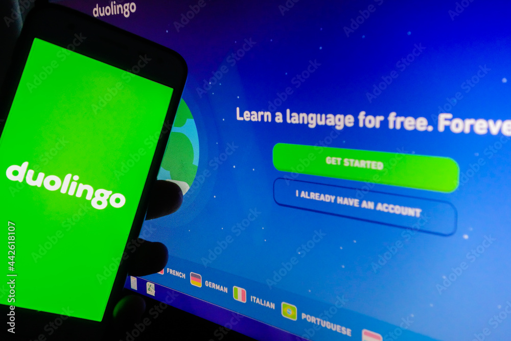 smartphone with Duolingo language app logo on screen. Blurred ...