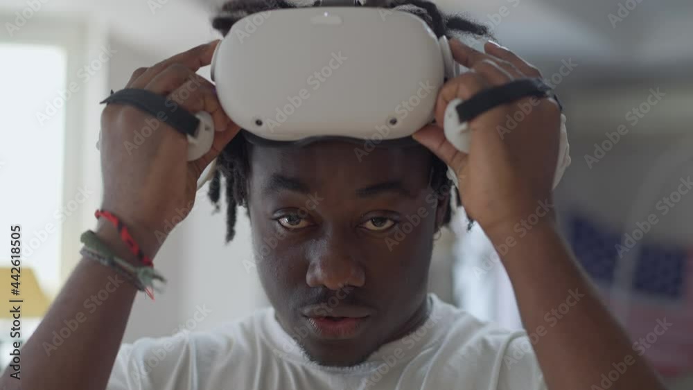 Close-up of satisfied gamer taking off VR headset showing thumbs up ...