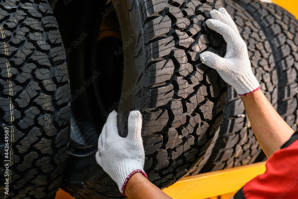 Asian male tire changer Checking the condition of off-road tires in ...