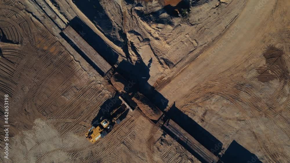 Wheel loader loading sand it to the freight train. Mining work in open ...