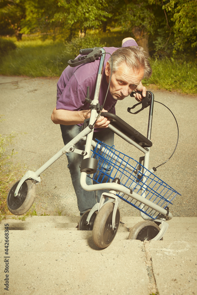 Older man overcoming obstacles with his four wheel rollator walker ...