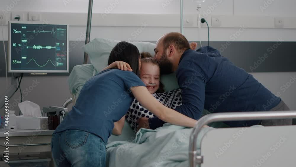 Happy parents visiting sick daughter hugging child during disease ...