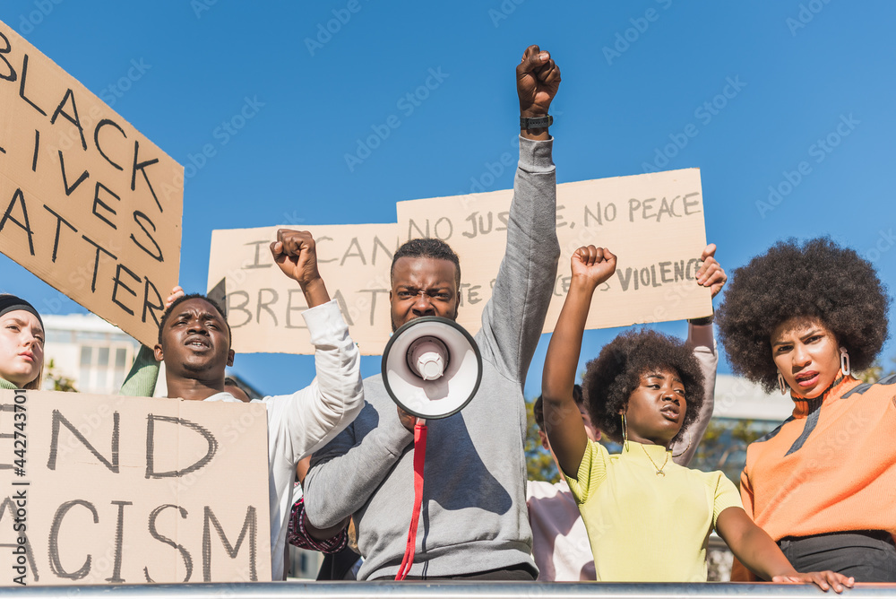 Black man protesting with megaphone in street Stock Photo | Adobe Stock