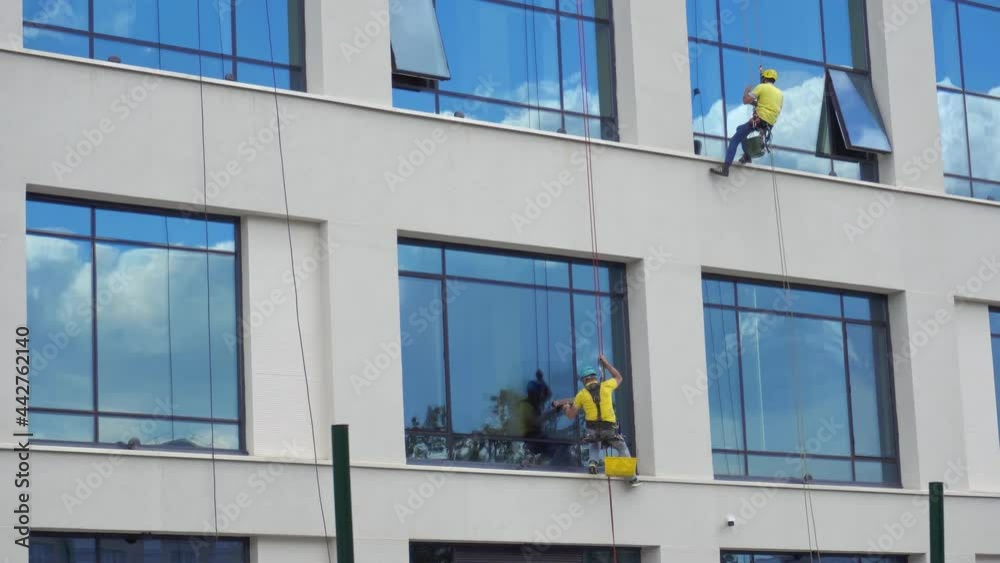 Glass window cleaners washers work outside the building. Professional ...
