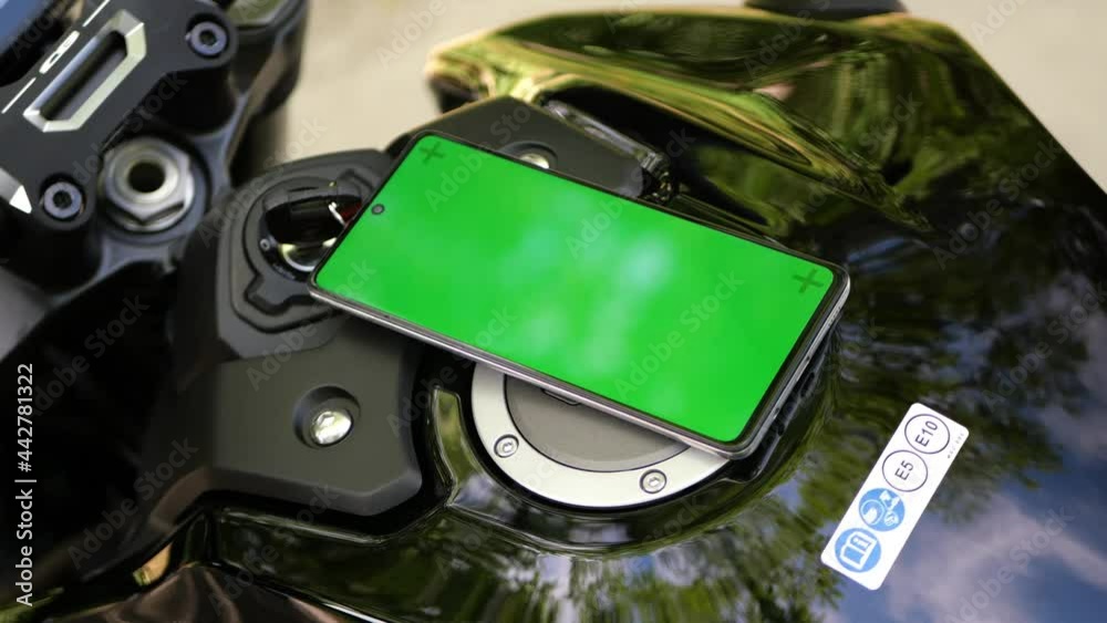 Modern smartphone with blank green screen chroma key on motorcycle gas ...
