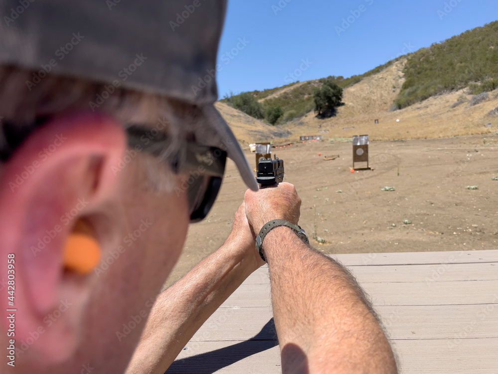 Foto de Man holding 9mm black handgun at the shooting range. The photo ...
