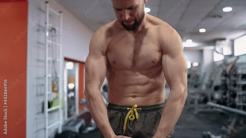 Frame of a muscular man who tenses his muscles in his hands and back ...