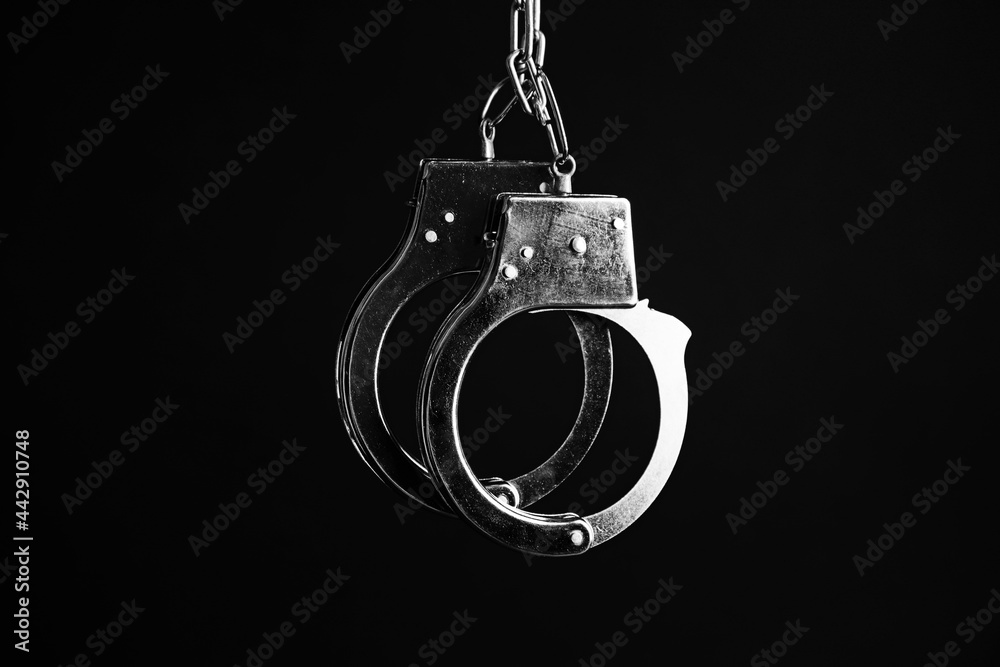 Classic chain handcuffs hanging on black background Stock Photo | Adobe ...
