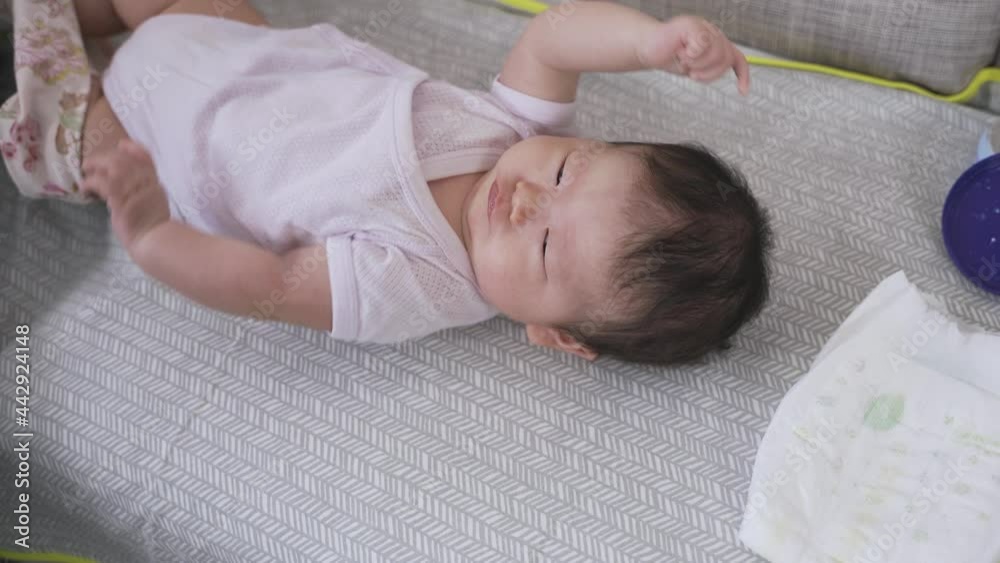 close up shot innocent baby girl is lying on the home sofa as its ...