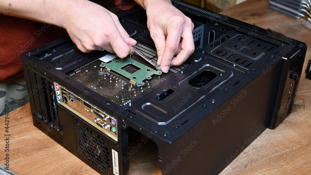 Technician hands assemble mini PC tower with brand new hardware. Man ...